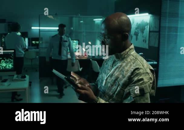 Medium side shot of African American army field commander in camouflage ...