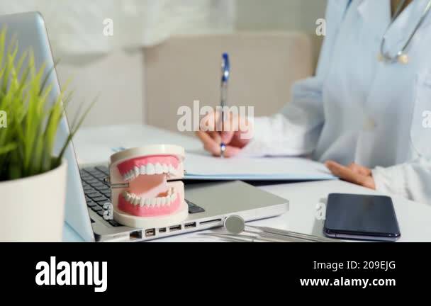 Oral dental. Dentist doctor in uniform writing information of patient ...