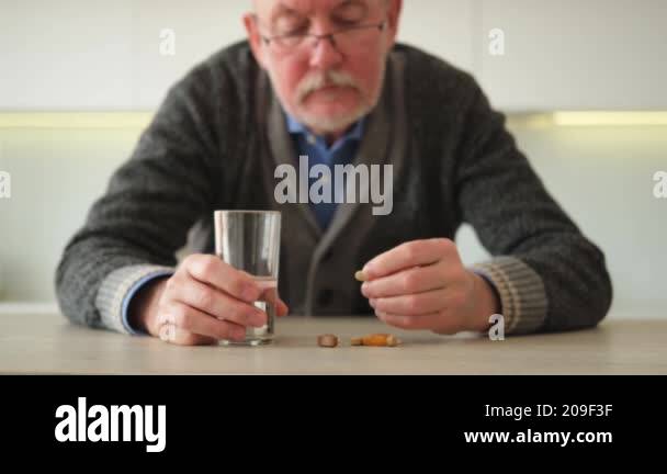 Middle aged senior man holding medical pill and glass of water. Mature ...