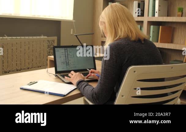 Rear view of focused professional middle aged female engineer creating ...