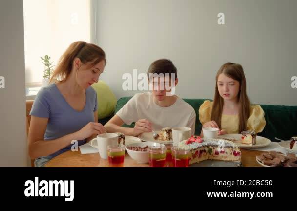 Family enjoying desserts together, sharing cake and snacks at table ...