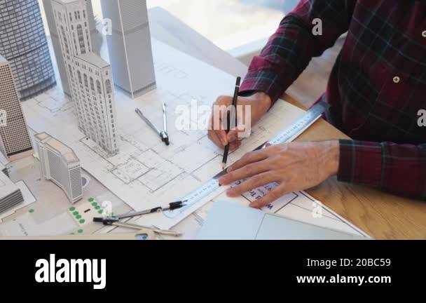 Indian male architect using compass to measure distance on urban city ...