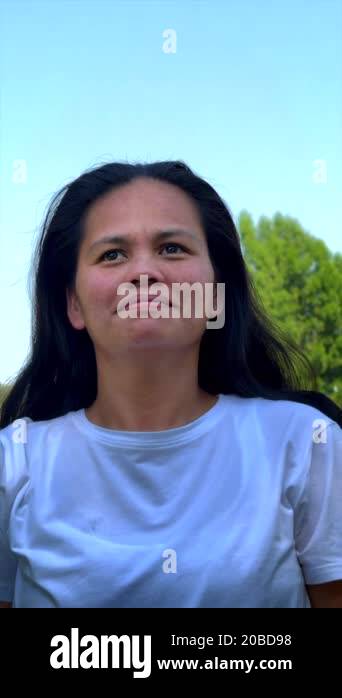 Strong, focused woman holds balanced yoga pose outdoors, surrounded by ...