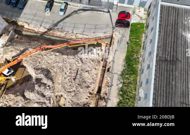 Aerial view of a construction site with heavy machinery and parked cars ...