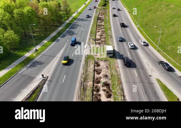 Aerial view of a highway with workers planting trees in the median ...