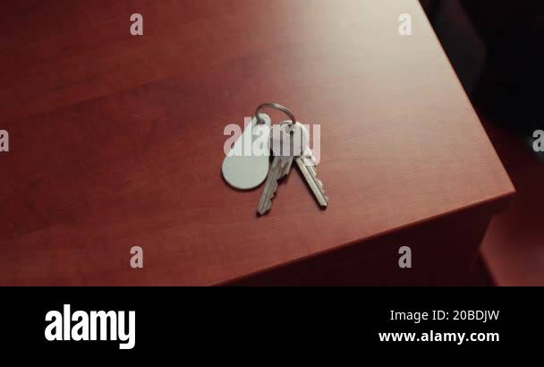 Room keys lying on a wooden desk, grabbing keys to go away and taking ...