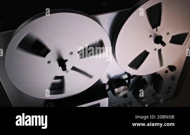 Close view of the spinning audio reels on a classic reel-to-reel tape ...