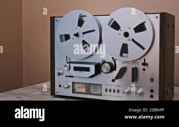 Close-up of a reel-to-reel tape recorder in action. The spools rapidly ...