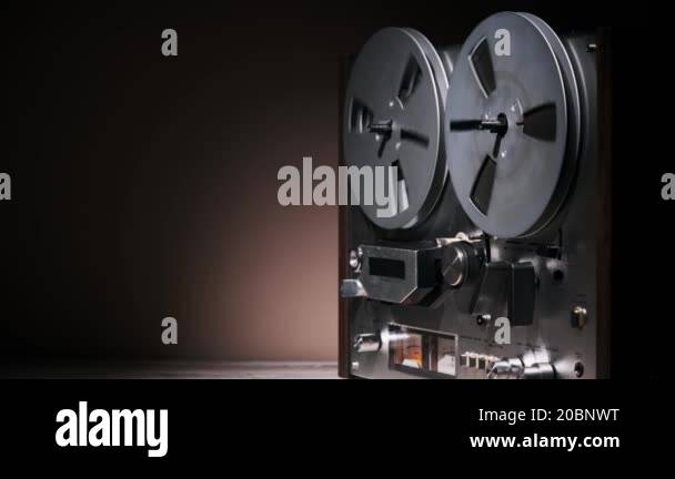 Vintage reel-to-reel tape recorder with its reels spinning ...