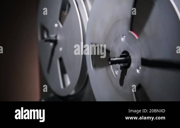 A dynamic close-up of spinning tape reels on a vintage audio recorder ...
