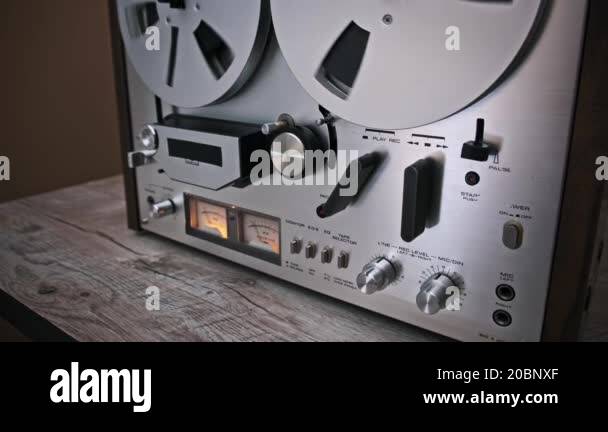 Close-up of a hand operating the PLAY lever on a retro reel-to-reel ...
