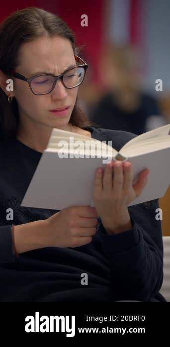 A young individual wearing glasses is completely absorbed in engrossed ...