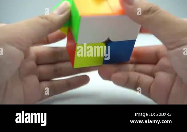 A hand solving the white part of a 2x2 Rubik's cube with a white ...