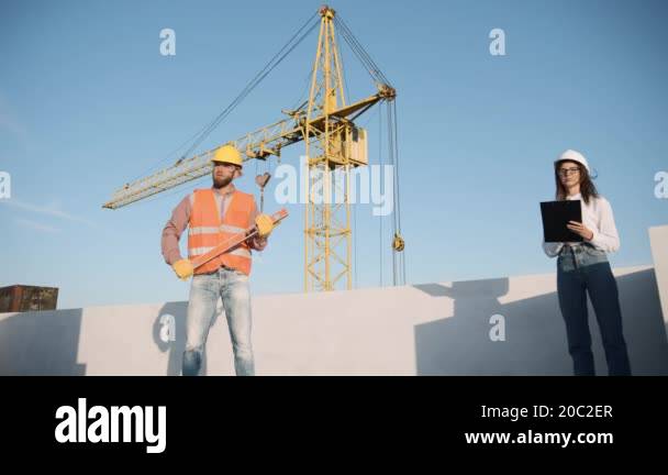 Construction worker using tools and reviewing plans on site with ...