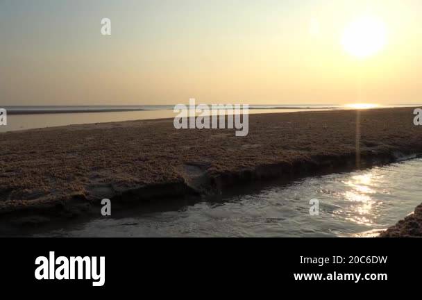 Beach landscape with morning sunrise, sunlight hitting the sand and ...
