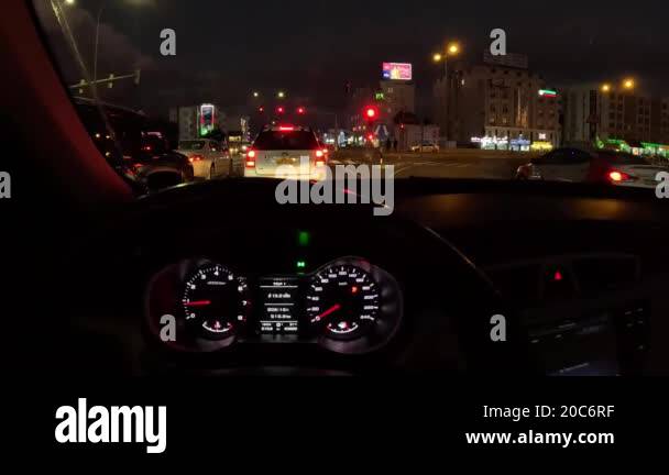 A speedometer view from windscreen urban scene at night, showcasing a ...