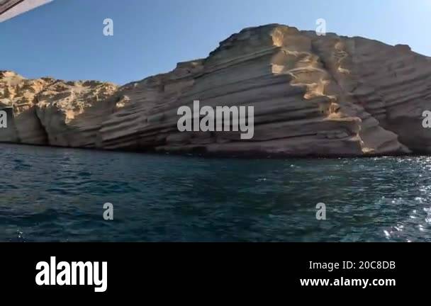 A magnificent rock formation juts out of the tranquil waters waves ...