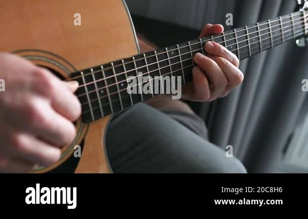Musician hands pressing guitar strings, producing melodic sound during ...