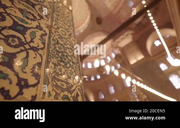 The mosque interior features intricate geometric tile patterns ...