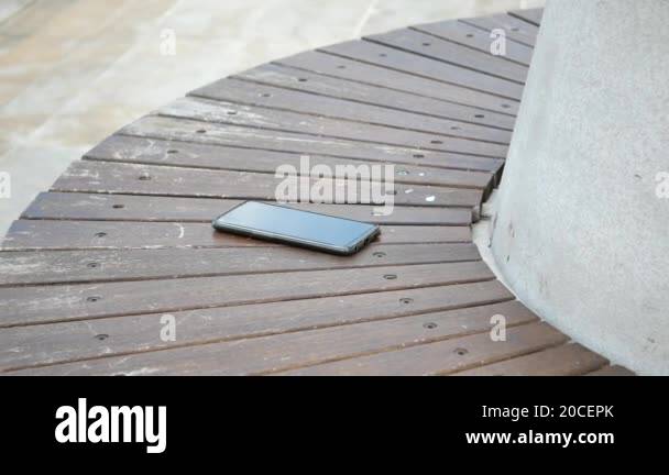 forget smartphone on a park bench, lost smart phone Stock Video Footage ...