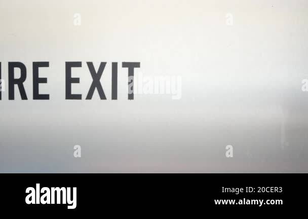 A visible fire exit sign stands out in a busy city near a vibrant ...