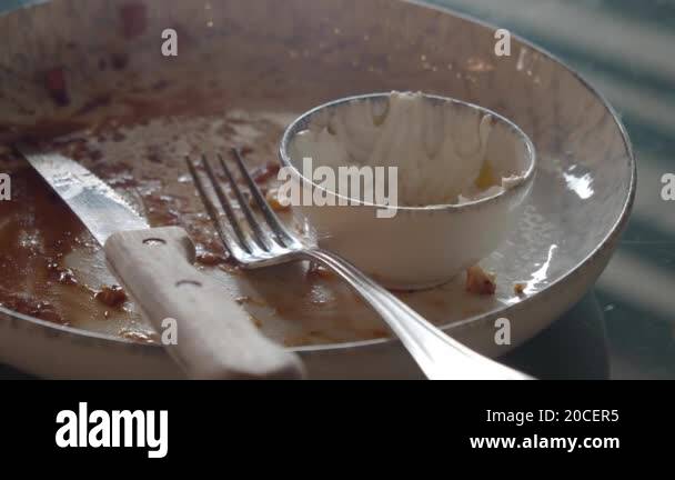 An empty plate and cutlery after a meal, showing the remnants of food ...