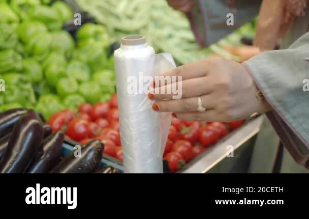A hand carefully selecting fresh and colorful produce in a vibrant ...