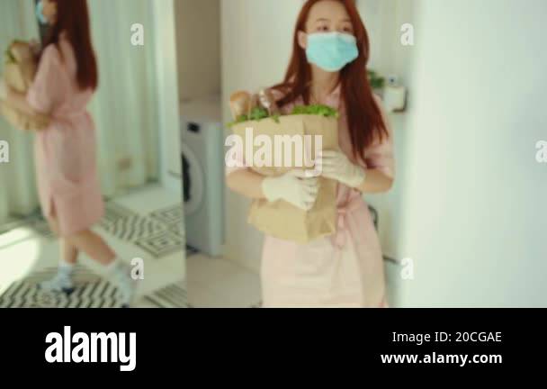 Stylish asian woman coming back home after food shopping entering house ...