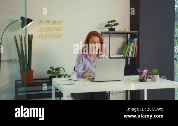 Attractive young sick and tired woman employee sitting at working place in modern office upset ...