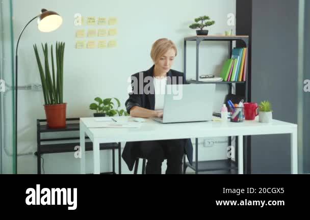 Sad businesswoman working in the office sitting at desk use laptop ...
