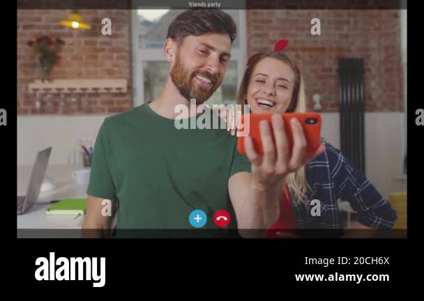 Beautiful young couple during a video call at the party with friends ...
