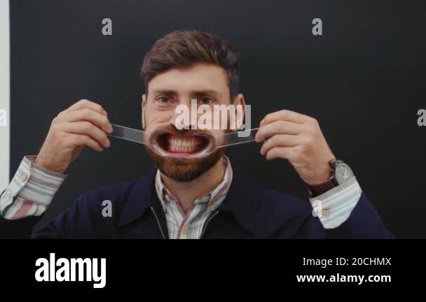 Close up young handsome man sitting look show teeth dentis takes ...