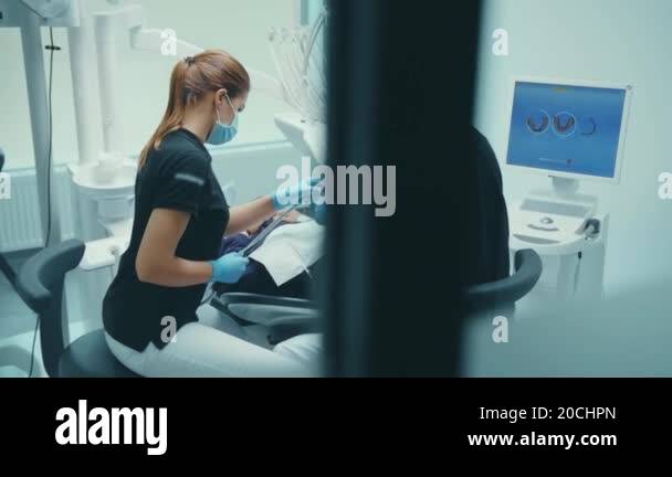Shot of dentist man with assistant and visiting man as client in professional lab of medical ...