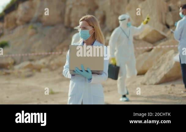 Close up woman worker ecology expert use laptop in mask working on land ...