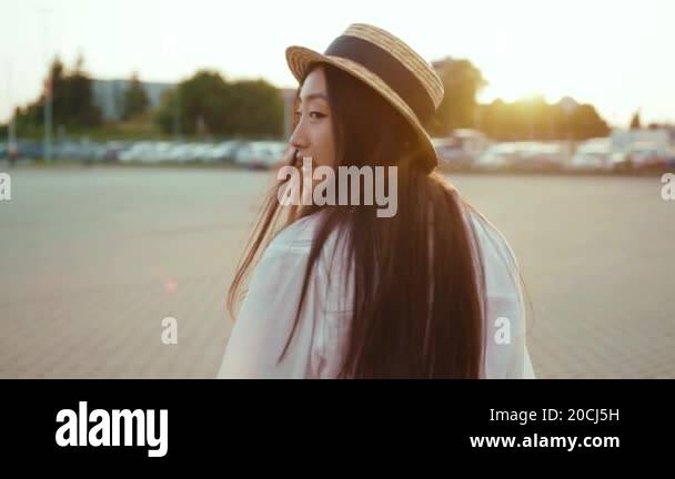 Charming and beautiful asian ethnicity young woman walking on sunny ...