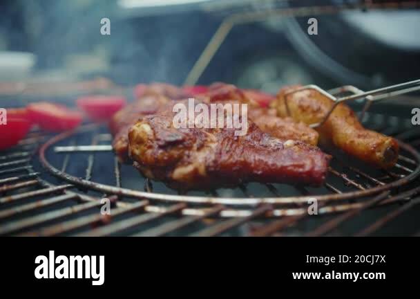 Close-up of man cooking barbecue meat turning over marinated juicy ...