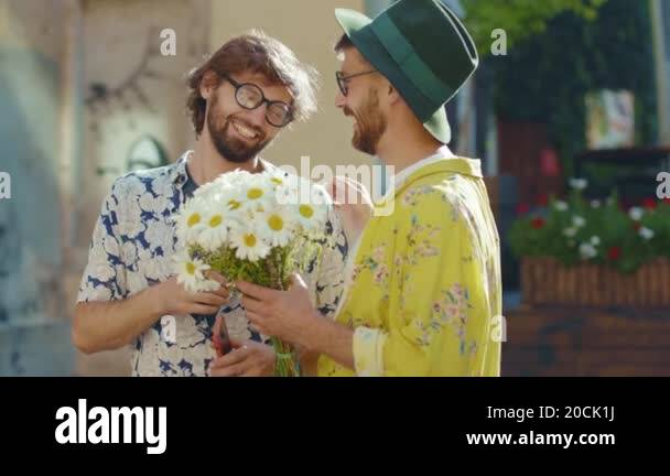 Young two gay men stand take picture with flowers at sunlight feel ...