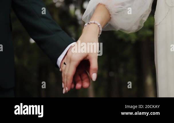 Wedding couple holding hands in park slow motion finger caucasian ...