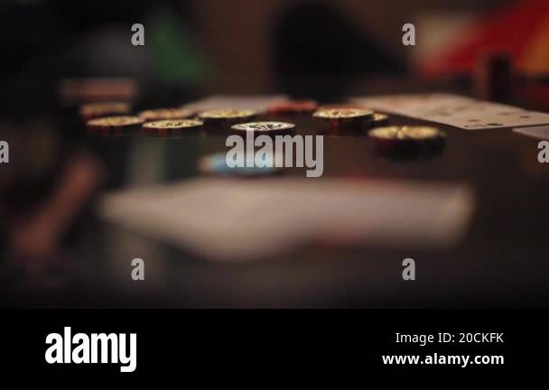 Close up focus view on poker chips and cards, blurred image of people ...