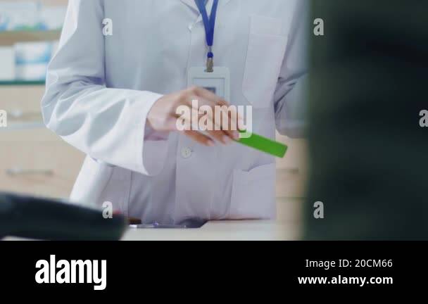 Handheld shot female pharmaceutist checking price of medication pack ...