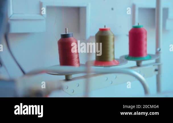 Close up spools of thread of different colors in the industrial sewing ...
