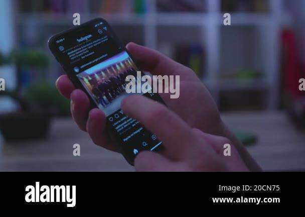 NEW YORK - May 19, 2019: At home hands man uses a phone touch scrolling ...