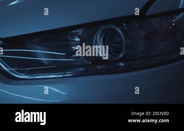 Extreme close-up of modern white car switched headlights flashing at ...