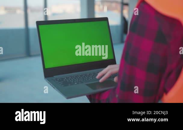 Close up hands engineer using laptop computer with green screen inside ...