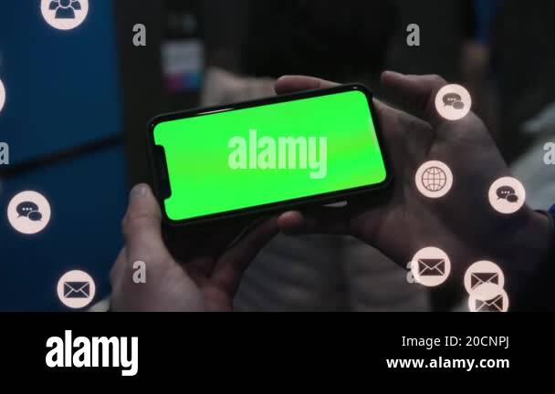 NEW YORK - 5 March, 2020: Close up of young man using smartphone with horizontal green screen ...