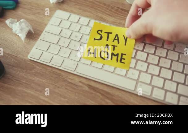 Hand of man laying a yellow note sticker remark on keyboard saying to ...