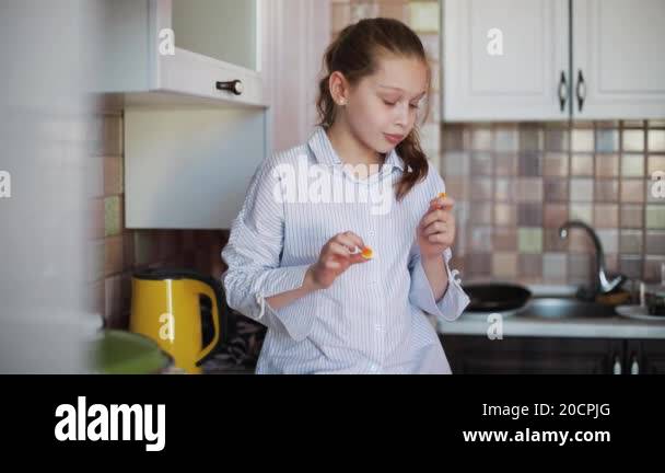 Charming young girl sitting eating looking at camera and smiling kid ...