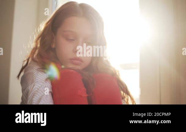 Portrait of a sad beautiful girl sitting at the window depression ...