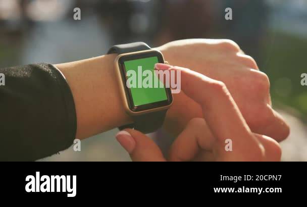 NEW YORK - April 5, 2018:Close up woman hands use smartwatch with green ...