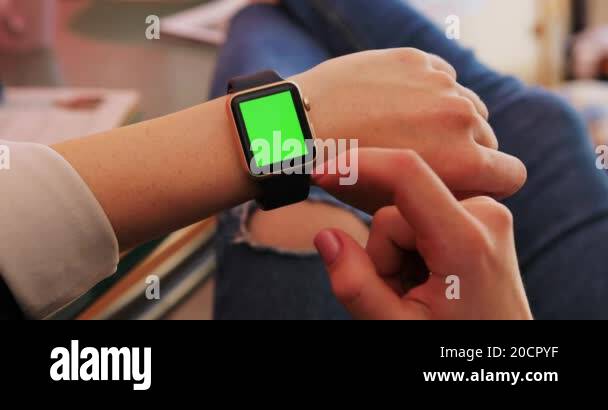 woman hands gestures on a modern smartwatch use with a green screen in ...